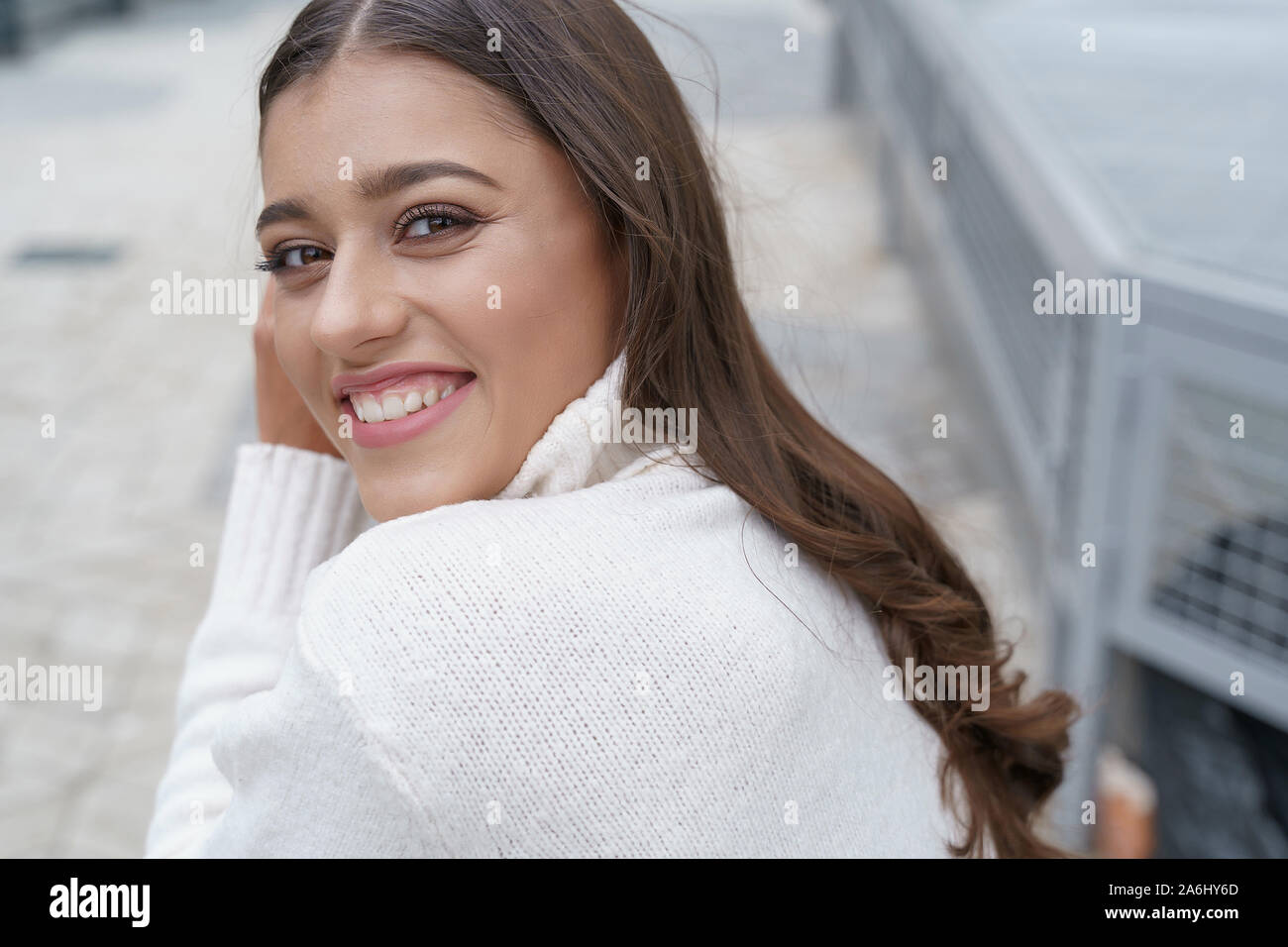 Beautiful young lady smiling and looking back standing outside Stock ...
