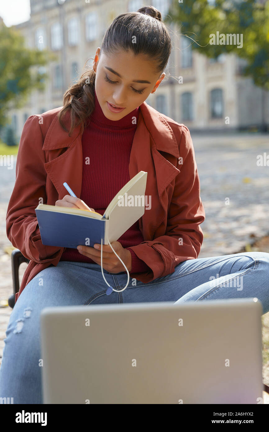 Good-looking young woman being focused writing in her notebook Stock ...
