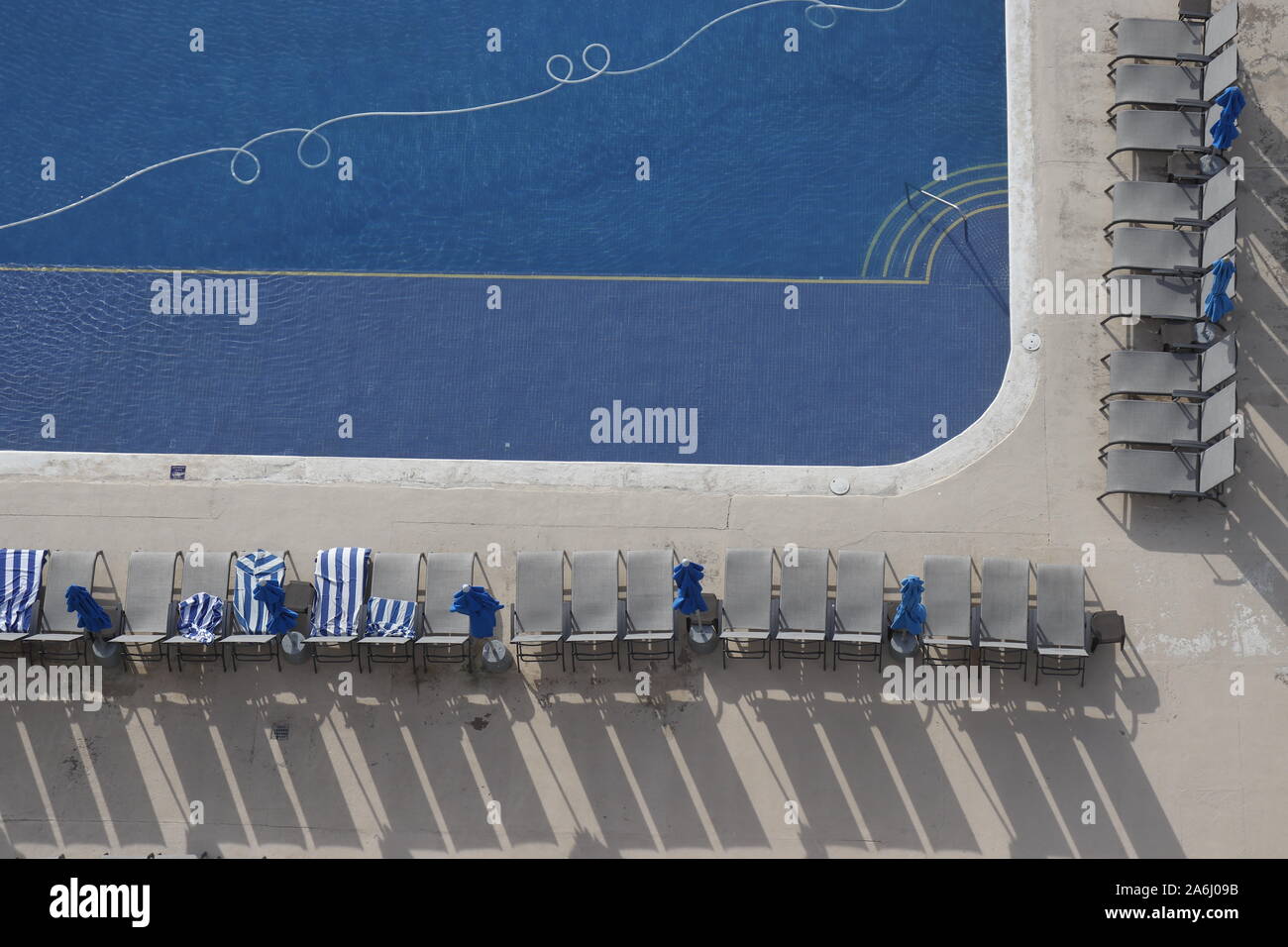 Poolside wth empty chairs seen from top before people arrive ...
