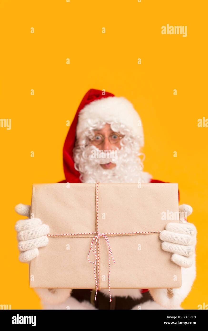 Santa Claus with human face holding Christmas present Stock Photo - Alamy