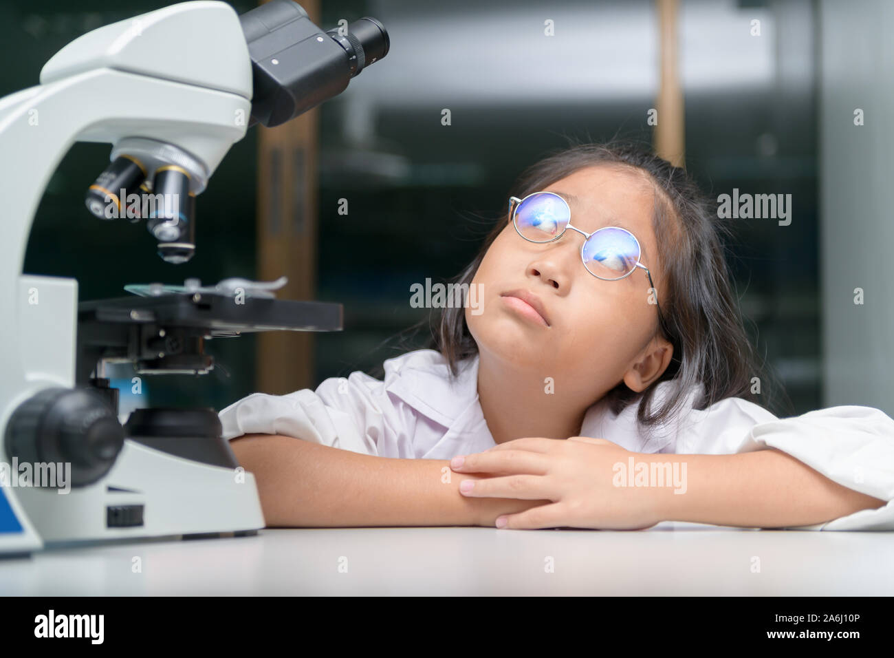 Little child with learning class in school laboratory using microscope ...