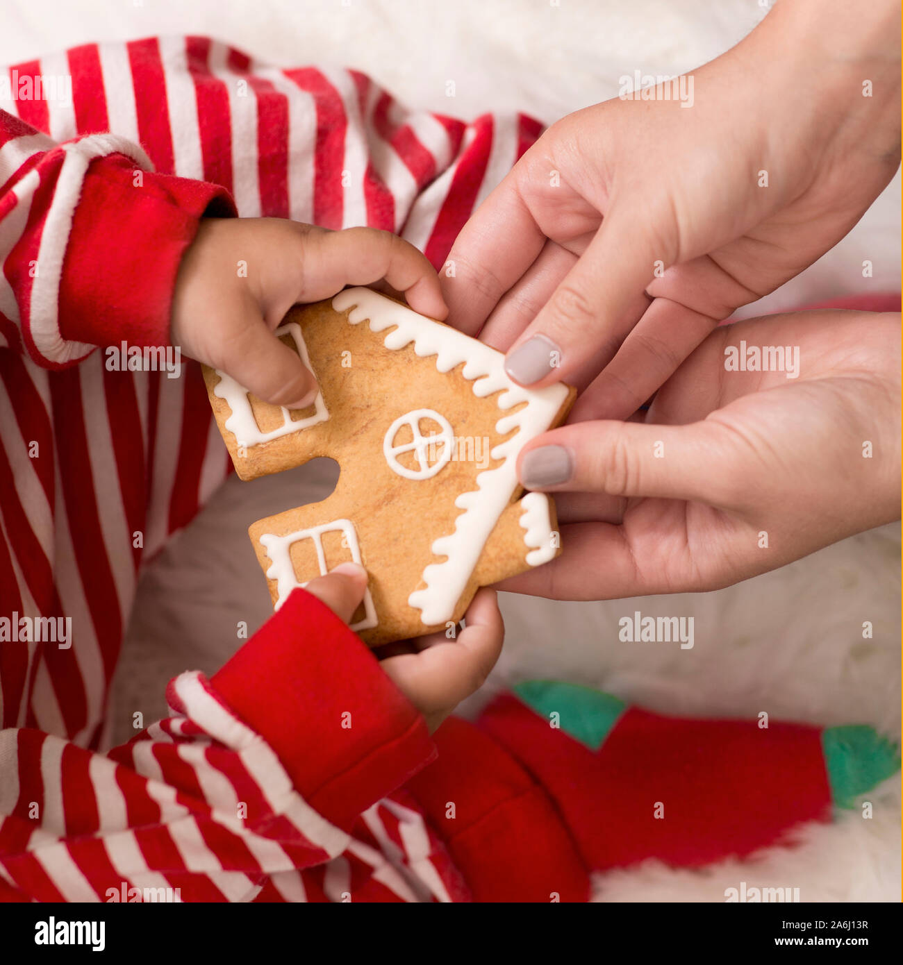 Baby taking Christmas gingerbread cookie from mother Stock Photo - Alamy