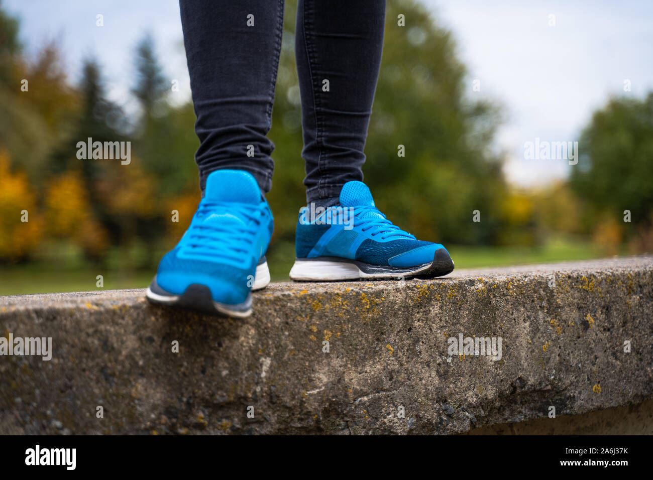 Blue sneakers on a woman legs. Outside workout in running shoes concept ...