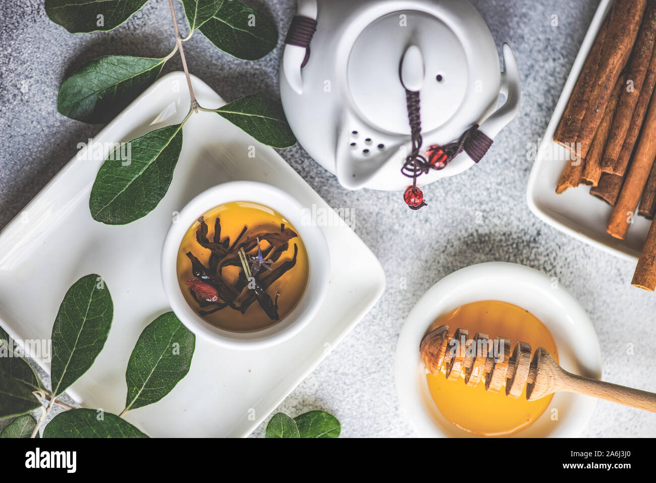 Floral tea concept with tea pot and cups on stone background with copy ...