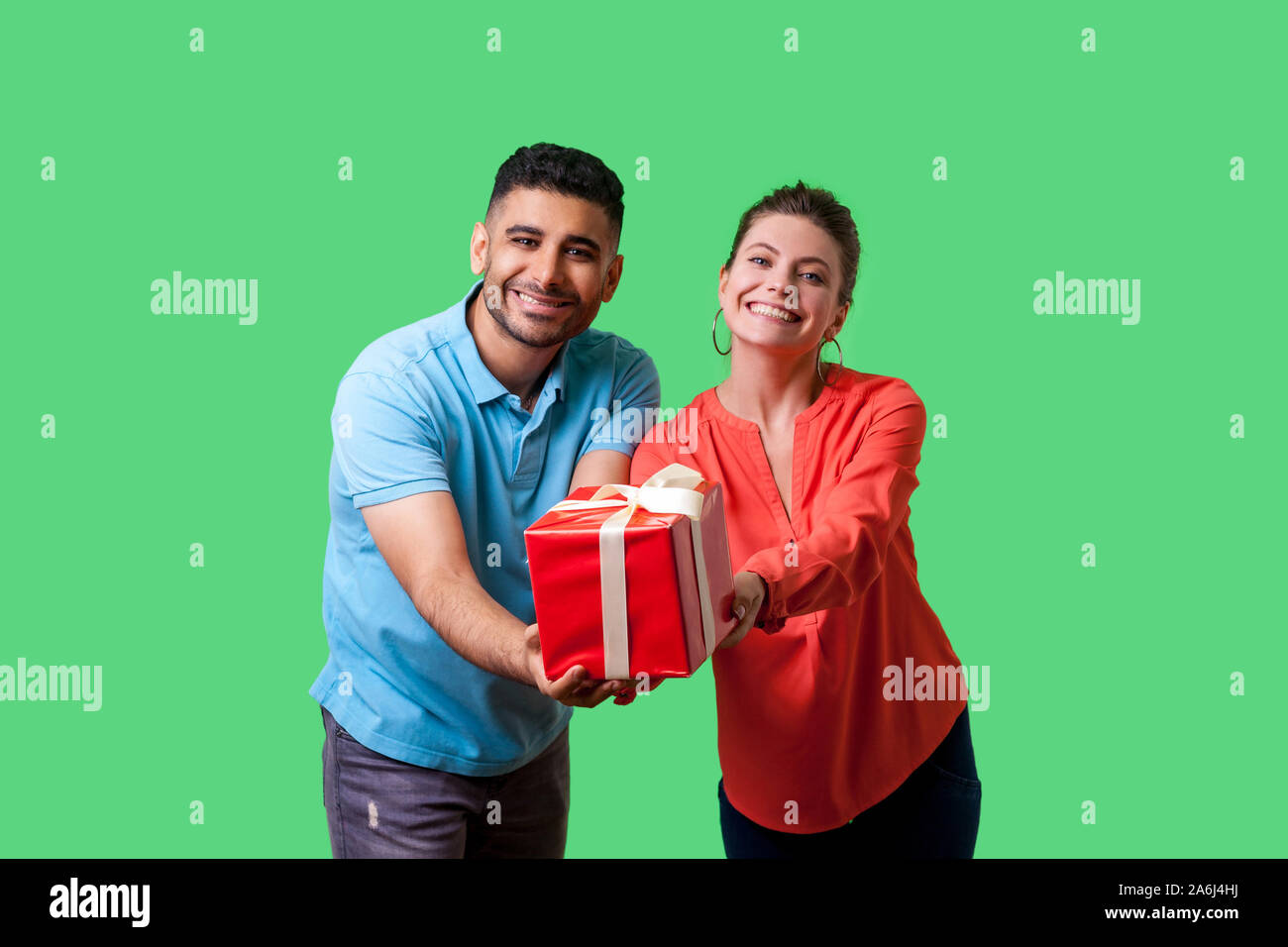 Please take your present! Young generous couple giving gift box to ...