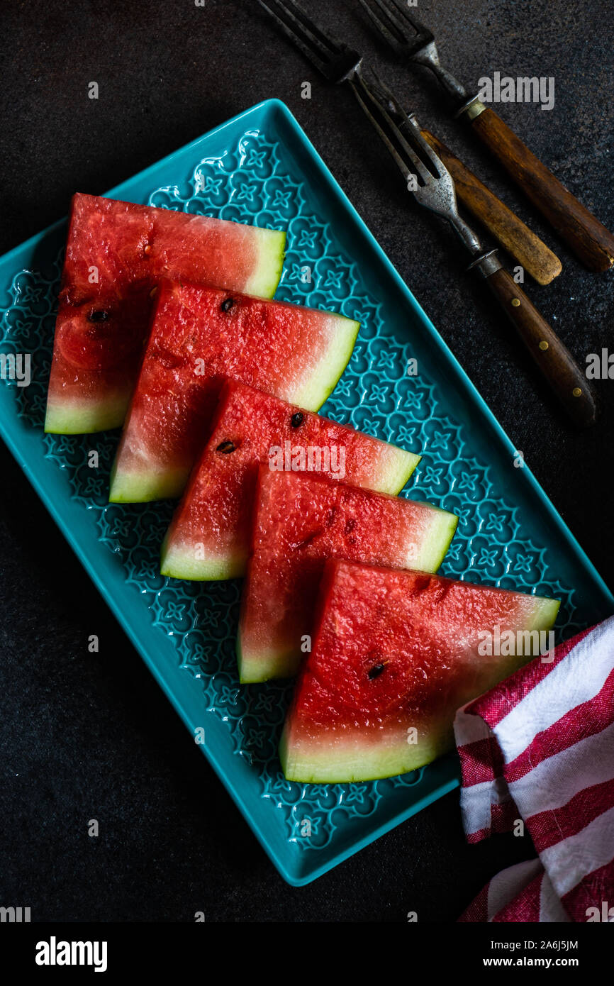 Organic watermelon slice on a plate served on stone background with ...
