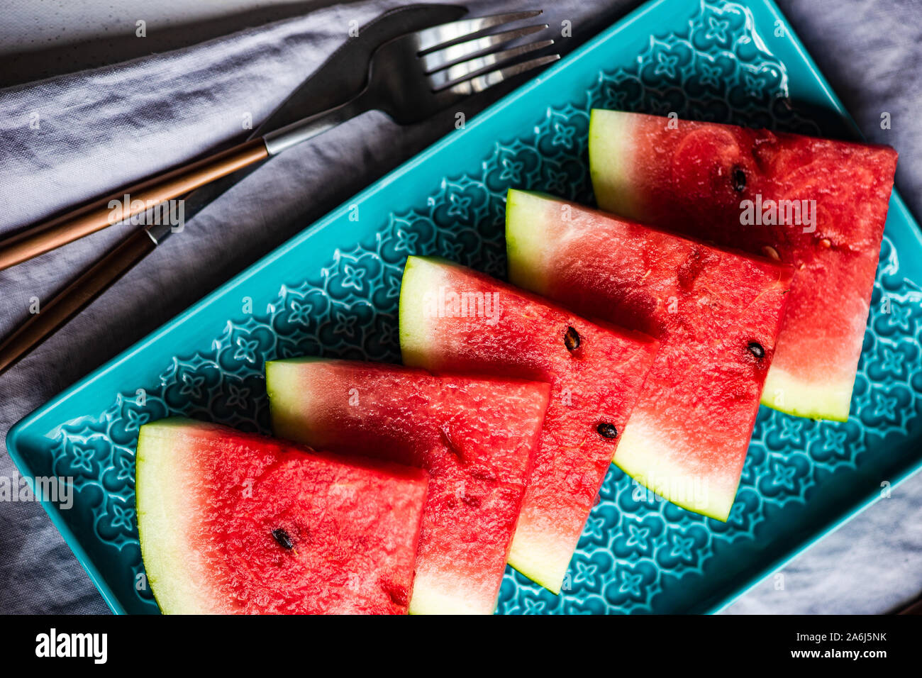 Organic watermelon slice on a plate served on stone background with ...