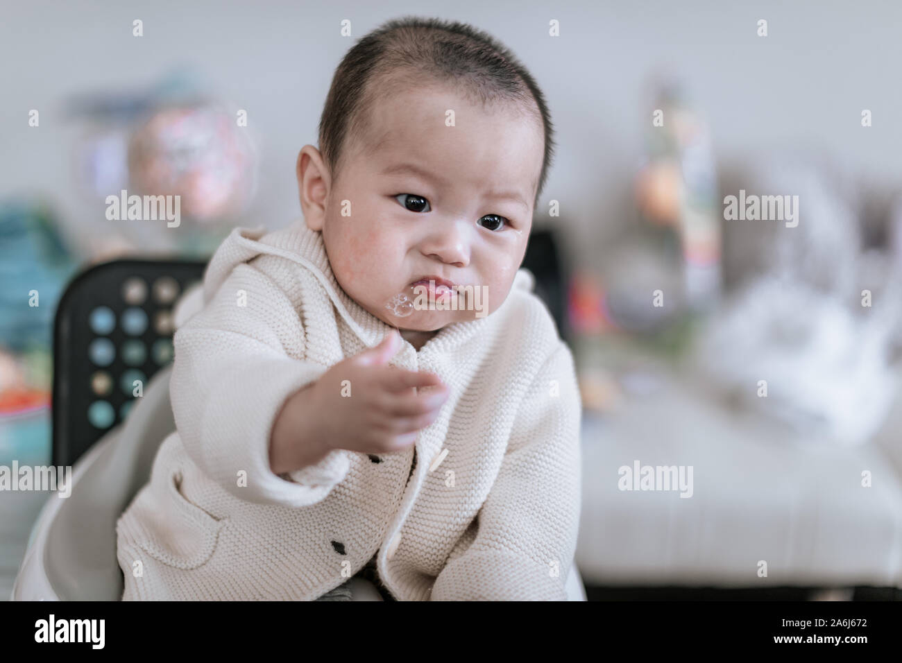 Cute baby boy sitting and raising his hand at home Stock Photo - Alamy