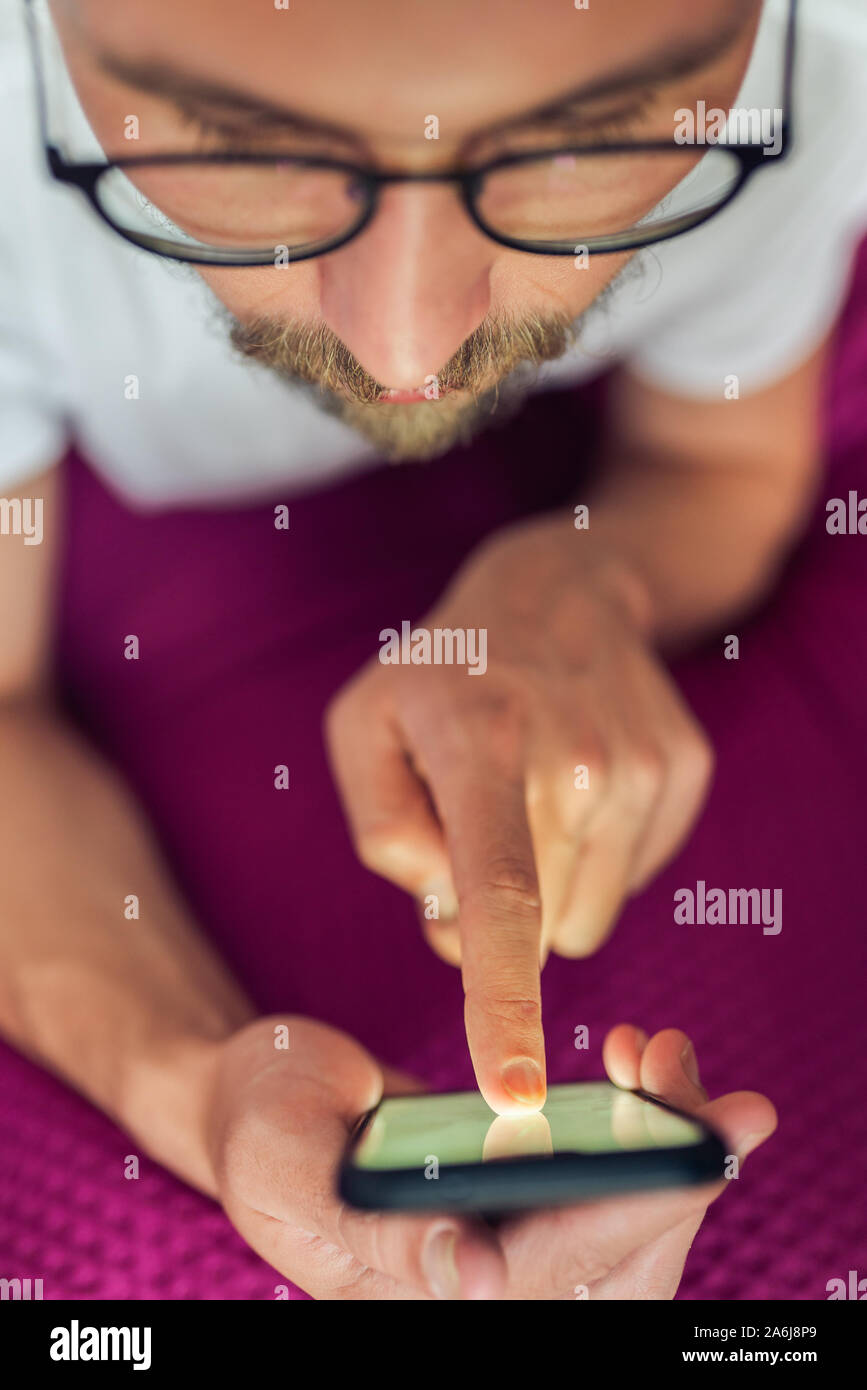 Photo of a rather serious young handsome man pressing something on the ...