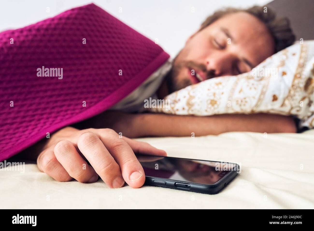 Sleeping young handsome man while holding his mobile phone. Screen on ...