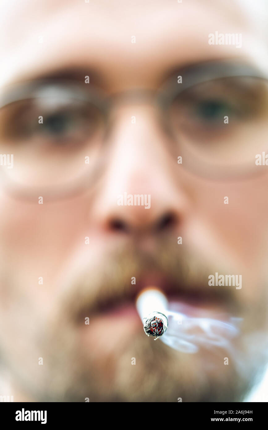 Close-up photo of a young man smoking a cigarette Stock Photo - Alamy
