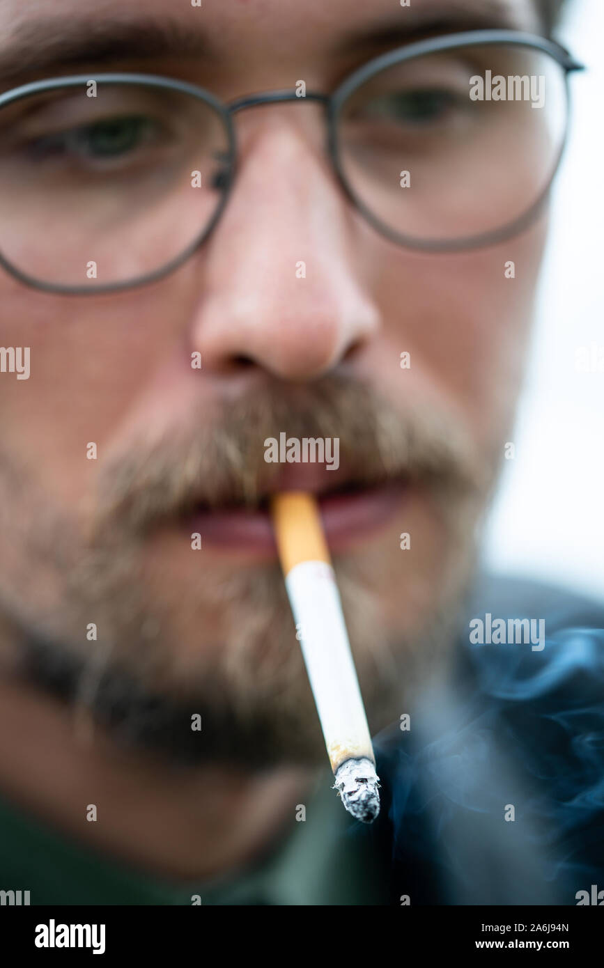 Close-up photo of a young man smoking a cigarette Stock Photo - Alamy