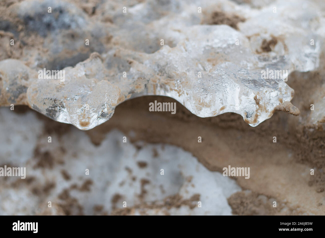Seashore ice mixed with snow and sand close up. Abstract background ...
