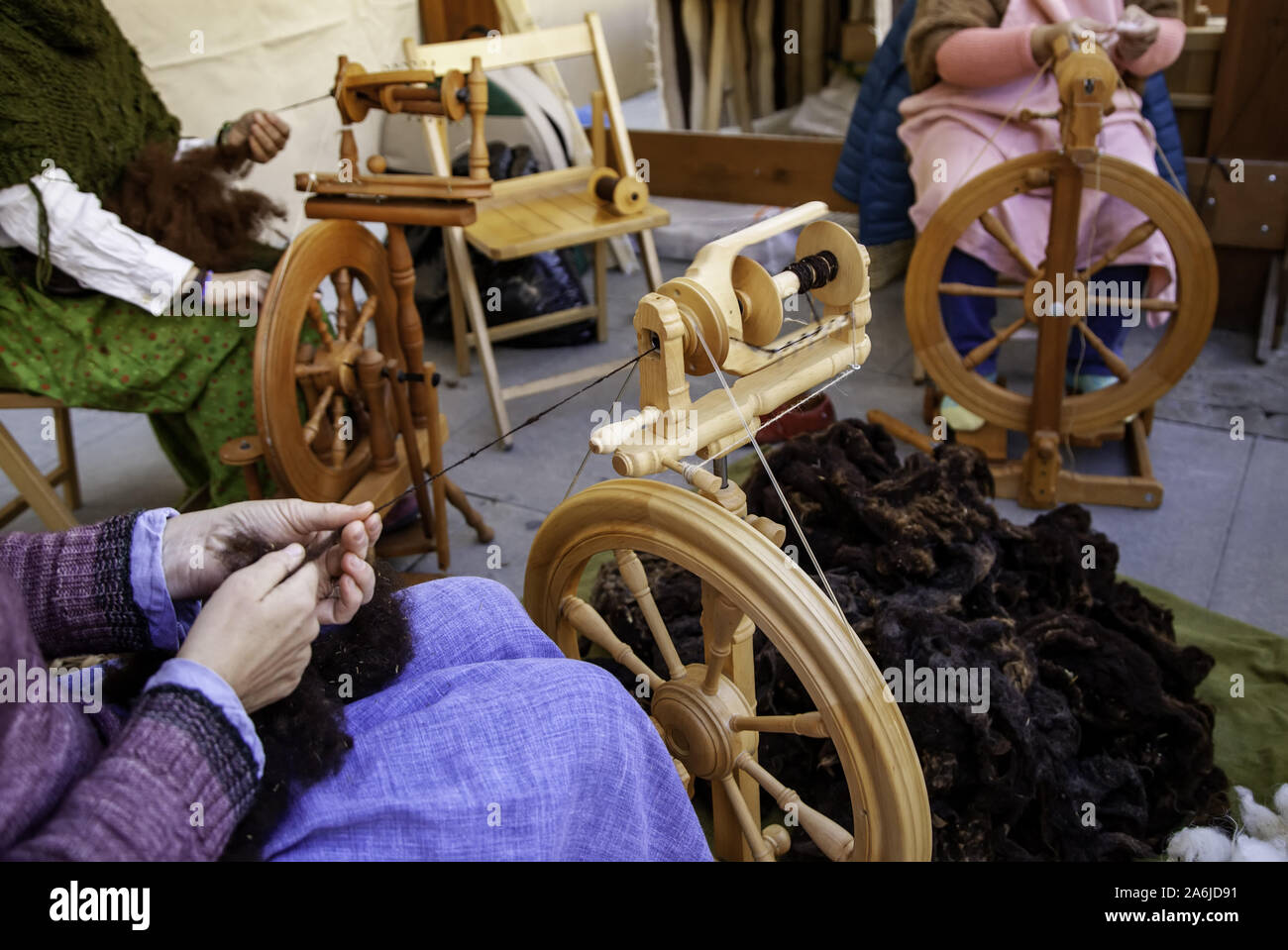 Spinning with a wooden spinning wheel, handicraft detail, thread ...