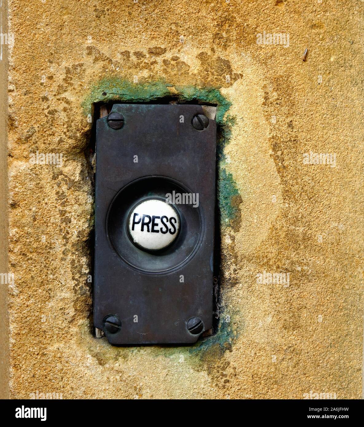 Close up of an old fashioned bell push set into a wall of Cotswold ...
