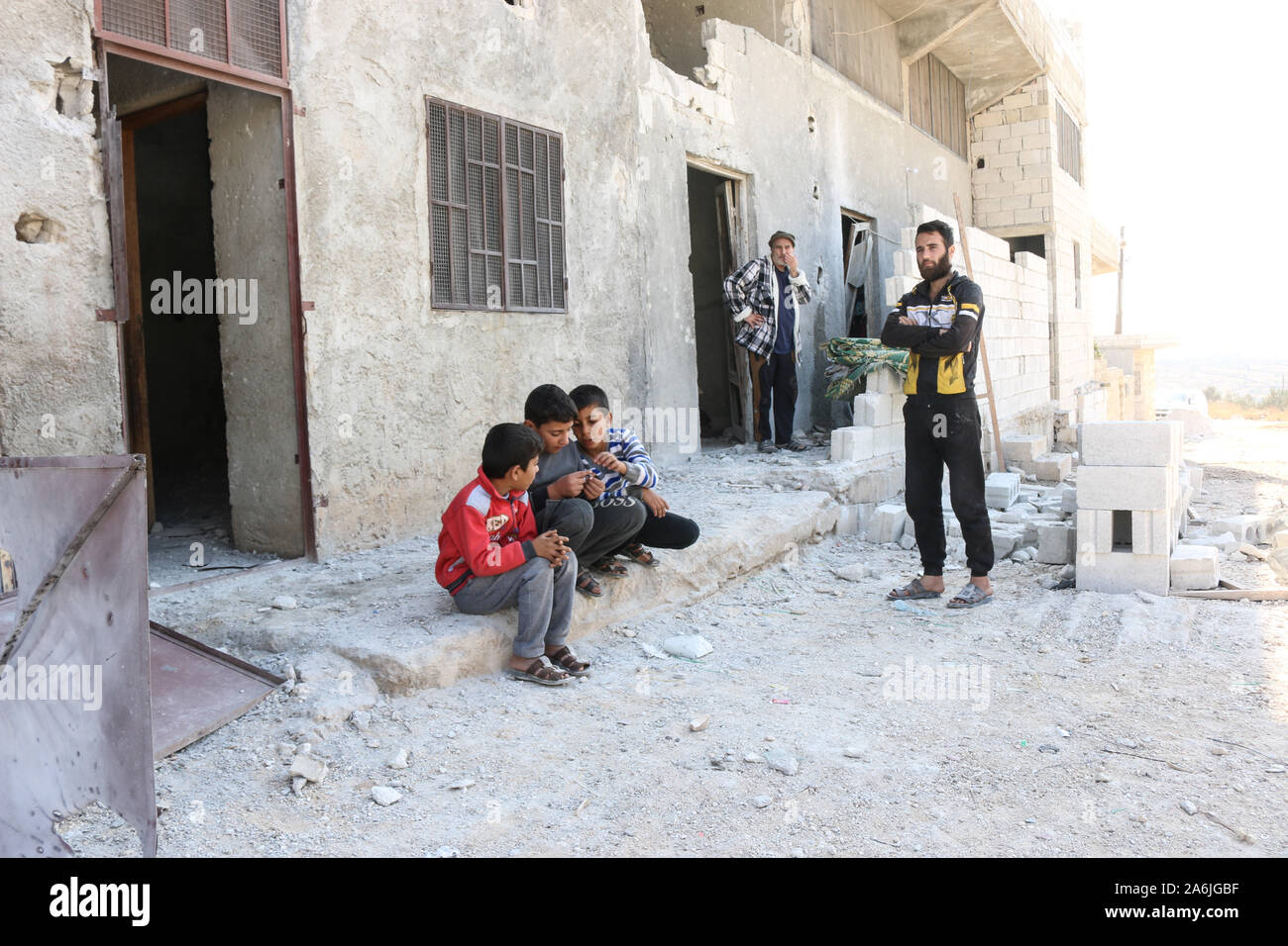 Barisha, Syria. 27th Oct, 2019. Syrians stand at the site near the ...