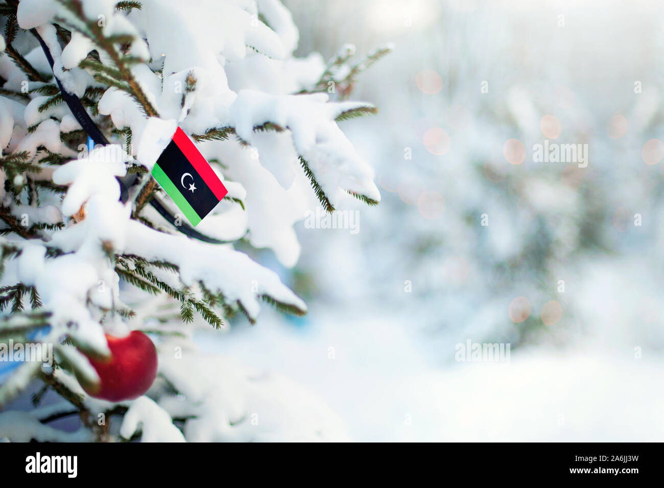 Christmas Libya. Xmas tree covered with snow, decorations and a flag ...