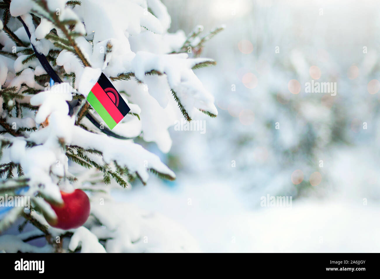 Christmas Malawi. Xmas tree covered with snow, decorations and a flag ...