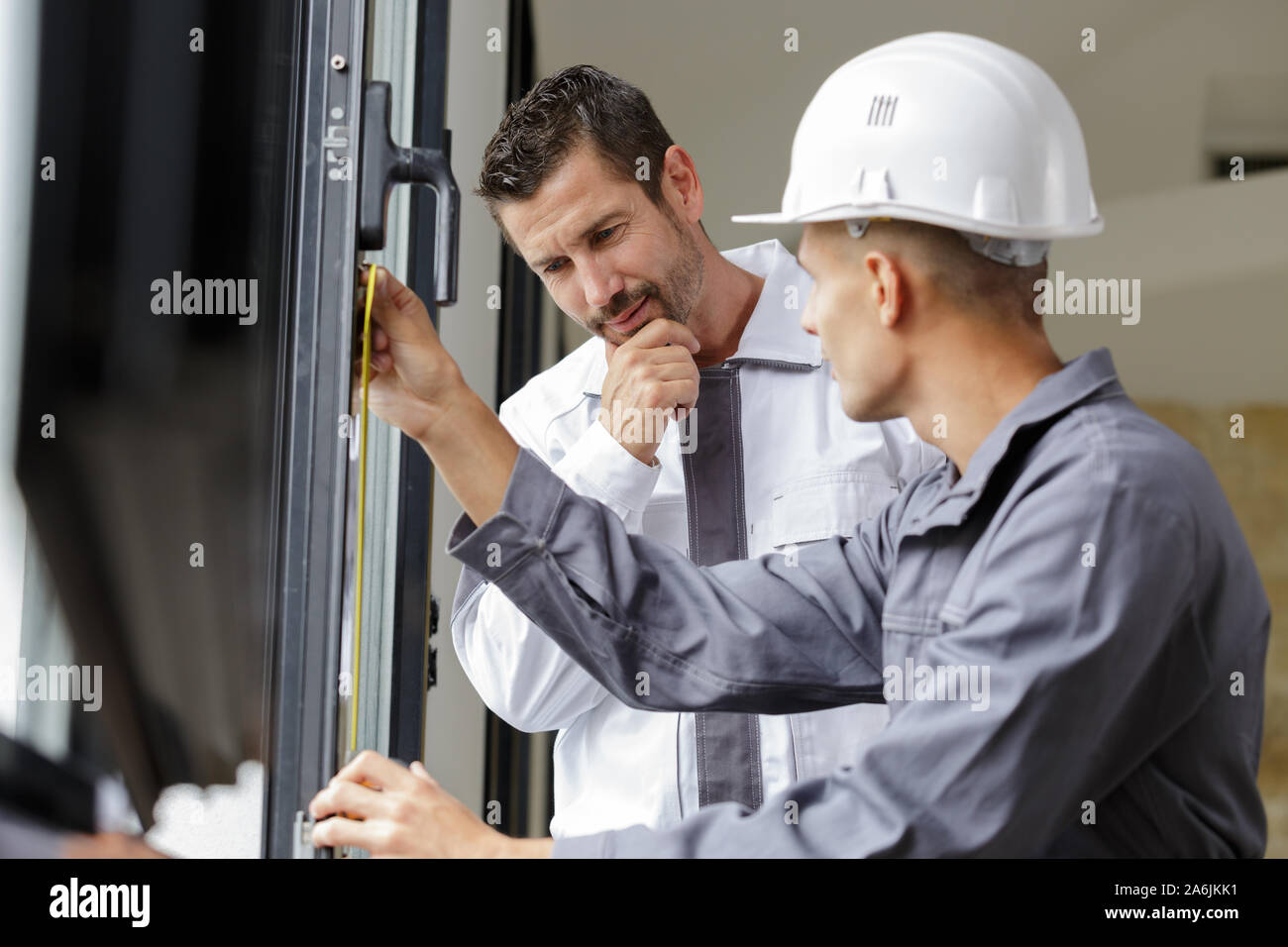 technician measuring the window with teacher Stock Photo - Alamy