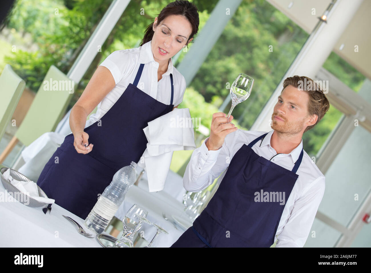 waiting staff setting table checking wineglass for smears Stock Photo ...