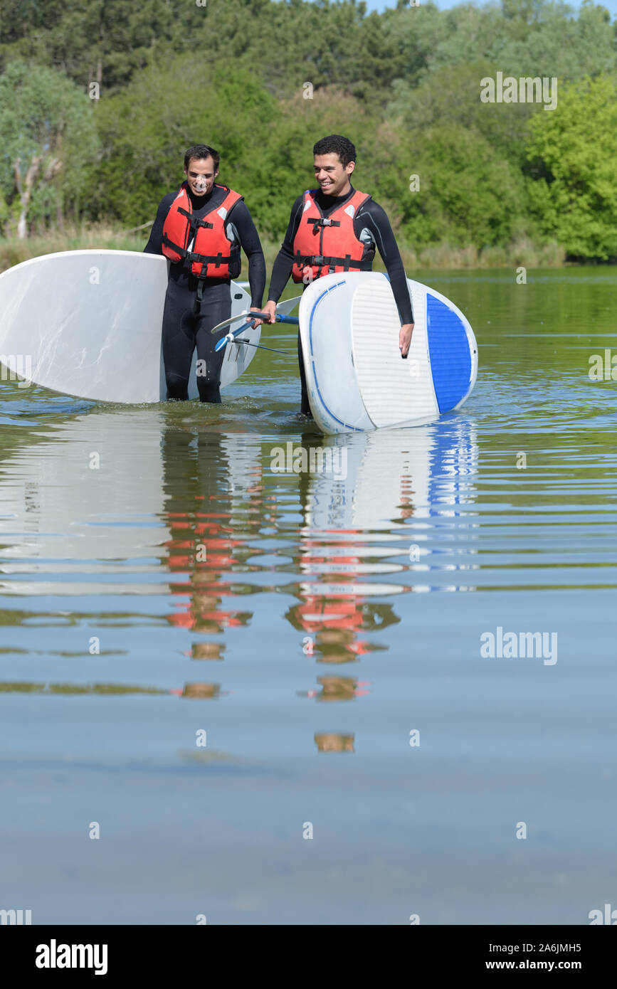 Man carrying paddle board hi-res stock photography and images - Alamy
