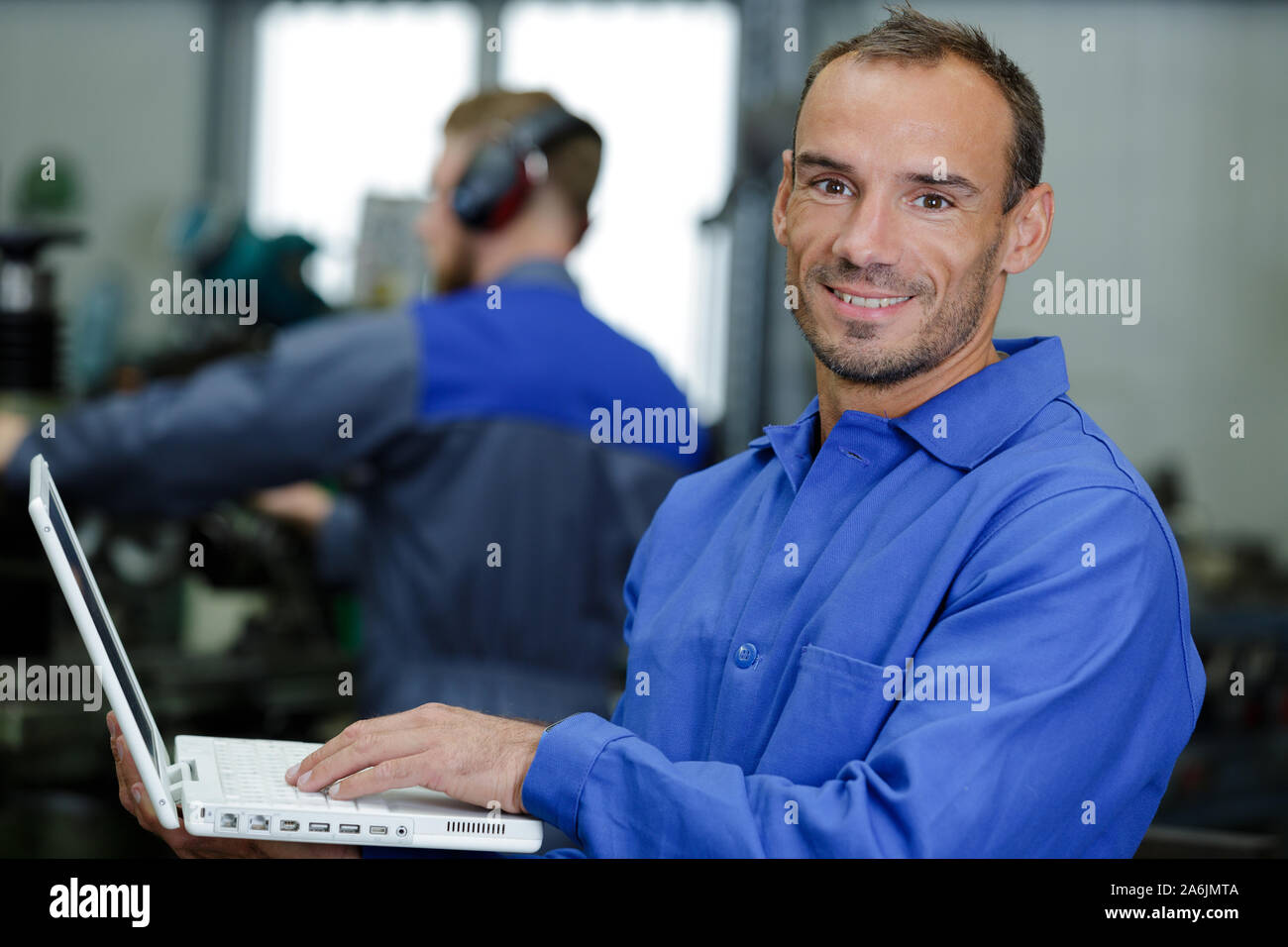 mechanic examining car engine with help of laptop Stock Photo - Alamy
