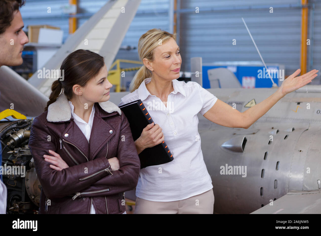 young people having guided tour of aviation hangar Stock Photo - Alamy
