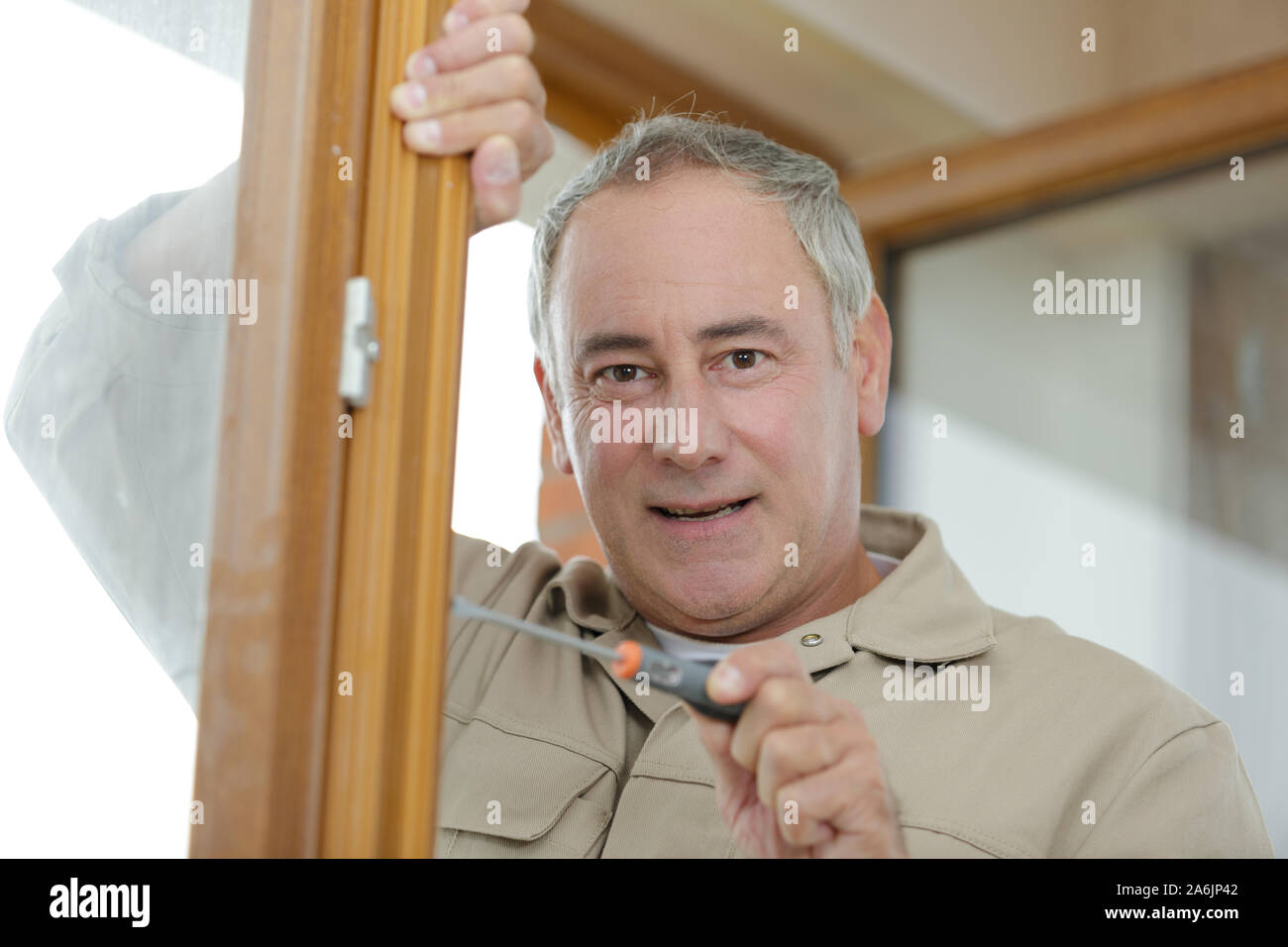 men screwing screws window frame Stock Photo - Alamy