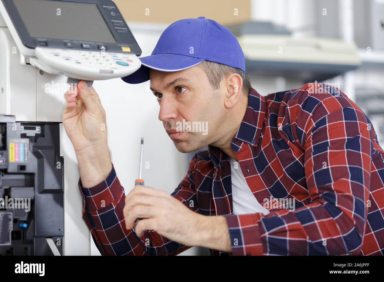 concentrated man repairing a printer Stock Photo - Alamy