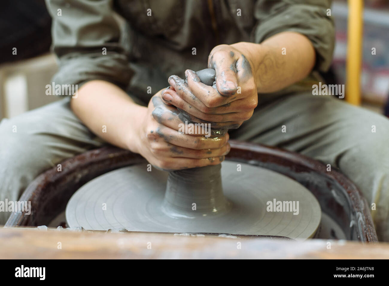 The girl sits at the Potter's wheel and creates a pot of ceramics. A ...