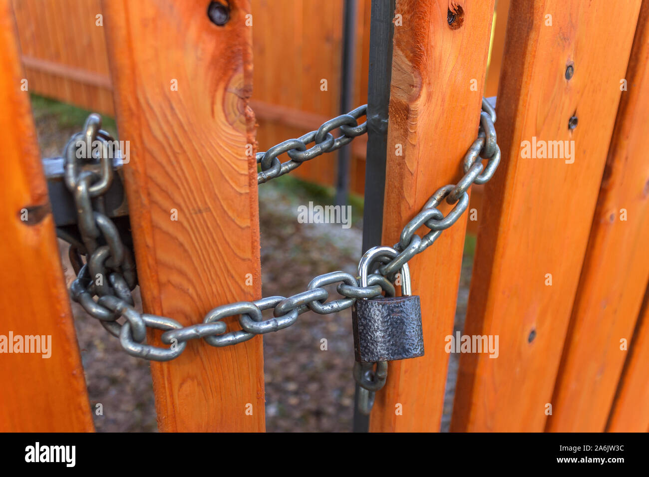 Steel chain with padlock locks the gates of a new wooden fence Stock ...