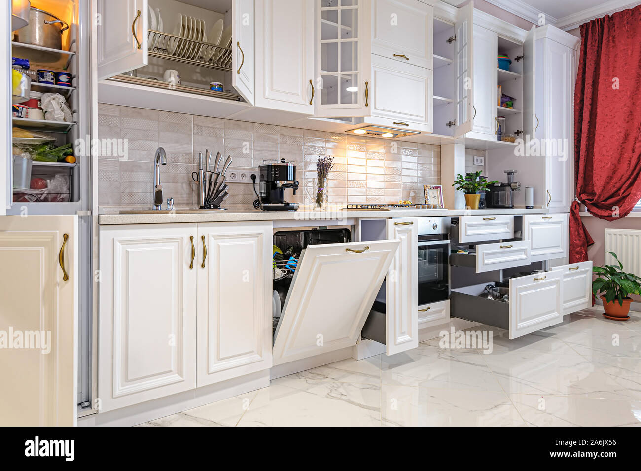 Luxury modern white kitchen interior with open doors and drawers Stock ...