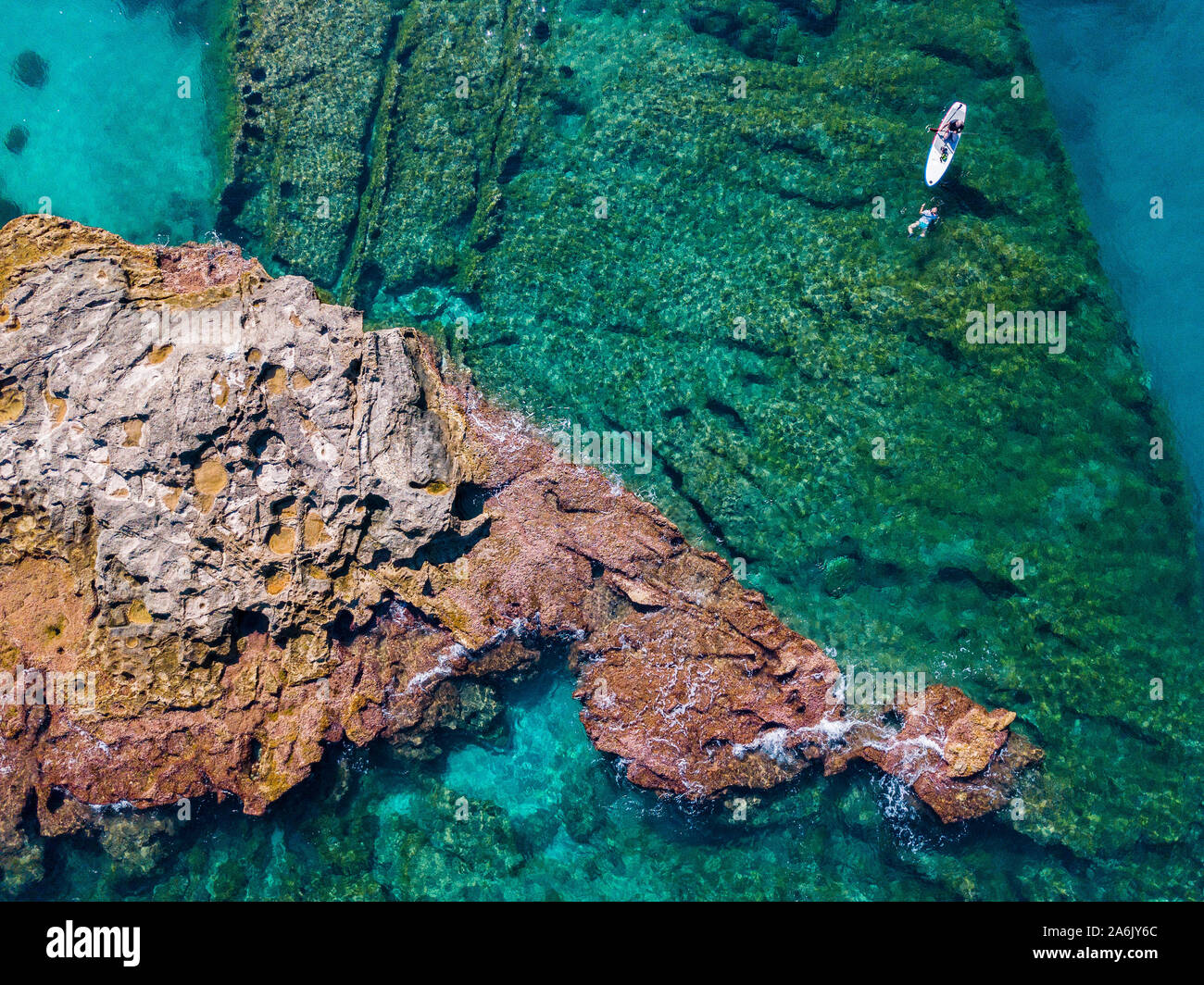 Aerial view of a paddle board in the water floating on a transparent ...