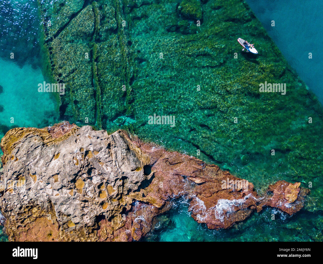 Aerial view of a paddle board in the water floating on a transparent ...