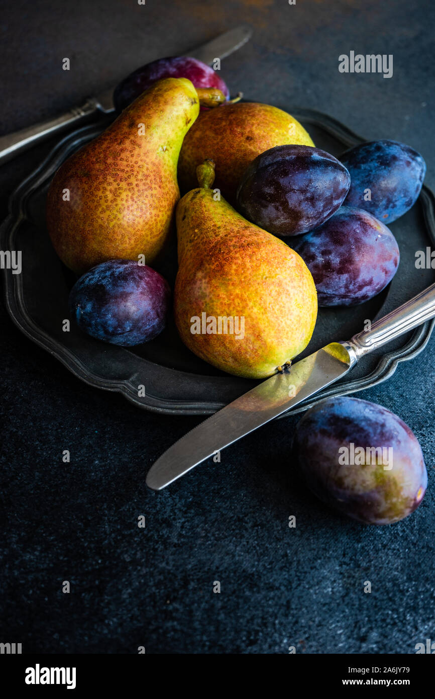 Oraganic fruits concept with pears and plums on dark bacground with ...