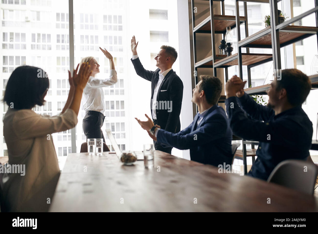 man congratulating his colleague with promotion, cheeful office workers ...