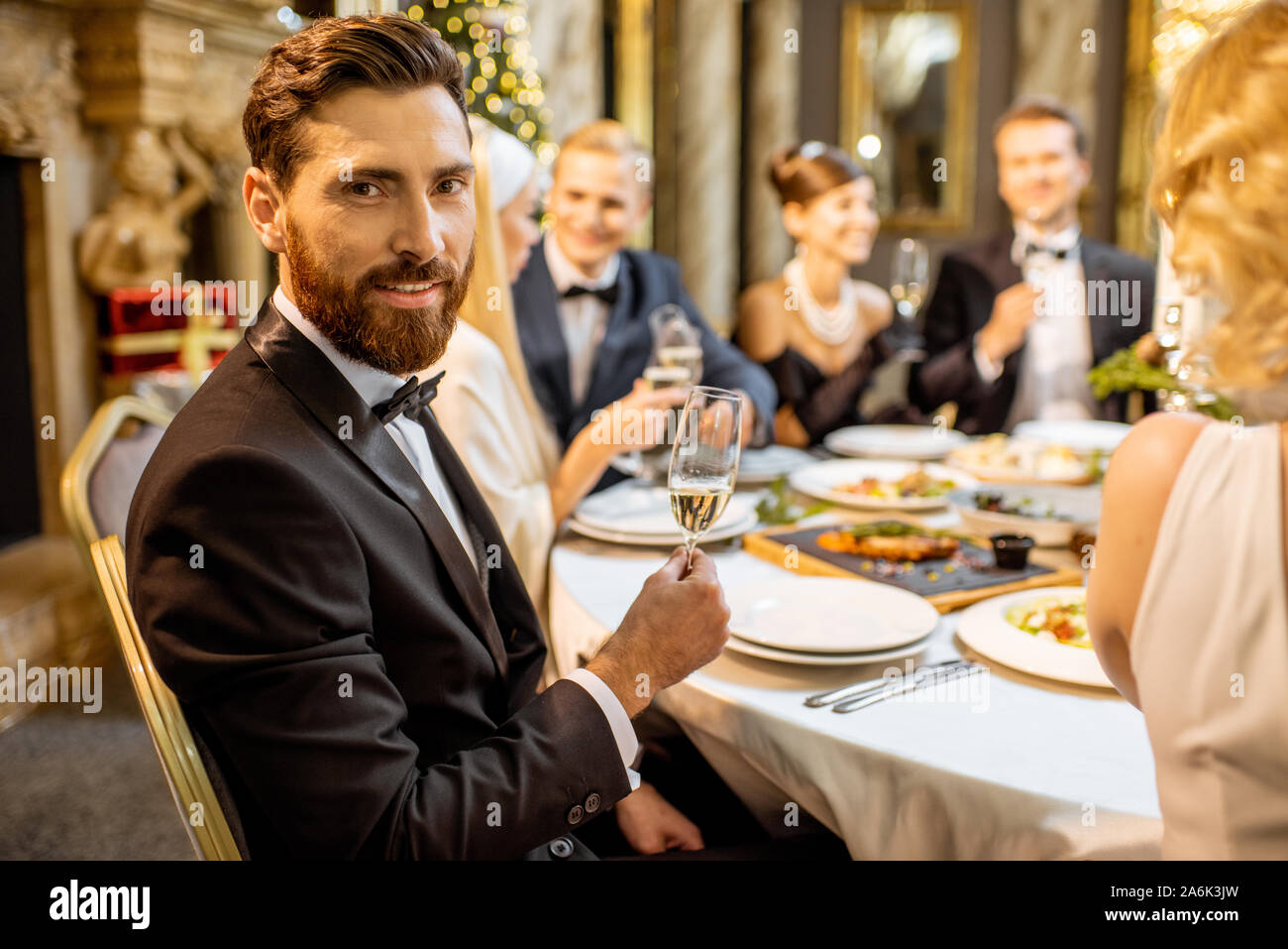 Portrait of a handsome well-dressed man sitting during a festive dinner ...