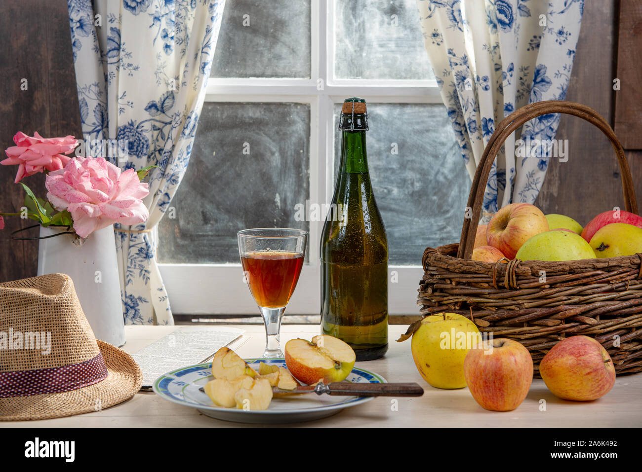 a bottle and glass of cider with apples. In rustic house Stock Photo ...