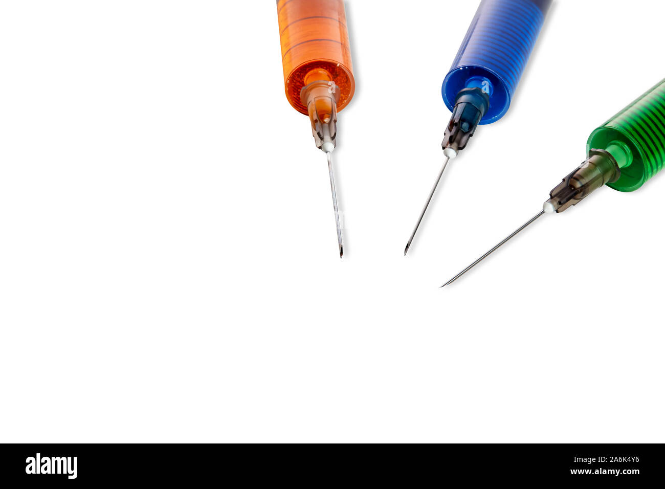 Three syringes filled with colorful liquids against white background ...