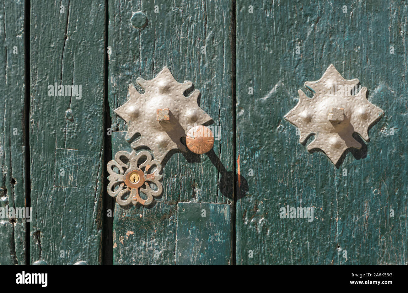 Green wooden door with texture and metal hardware and star-shaped locks ...