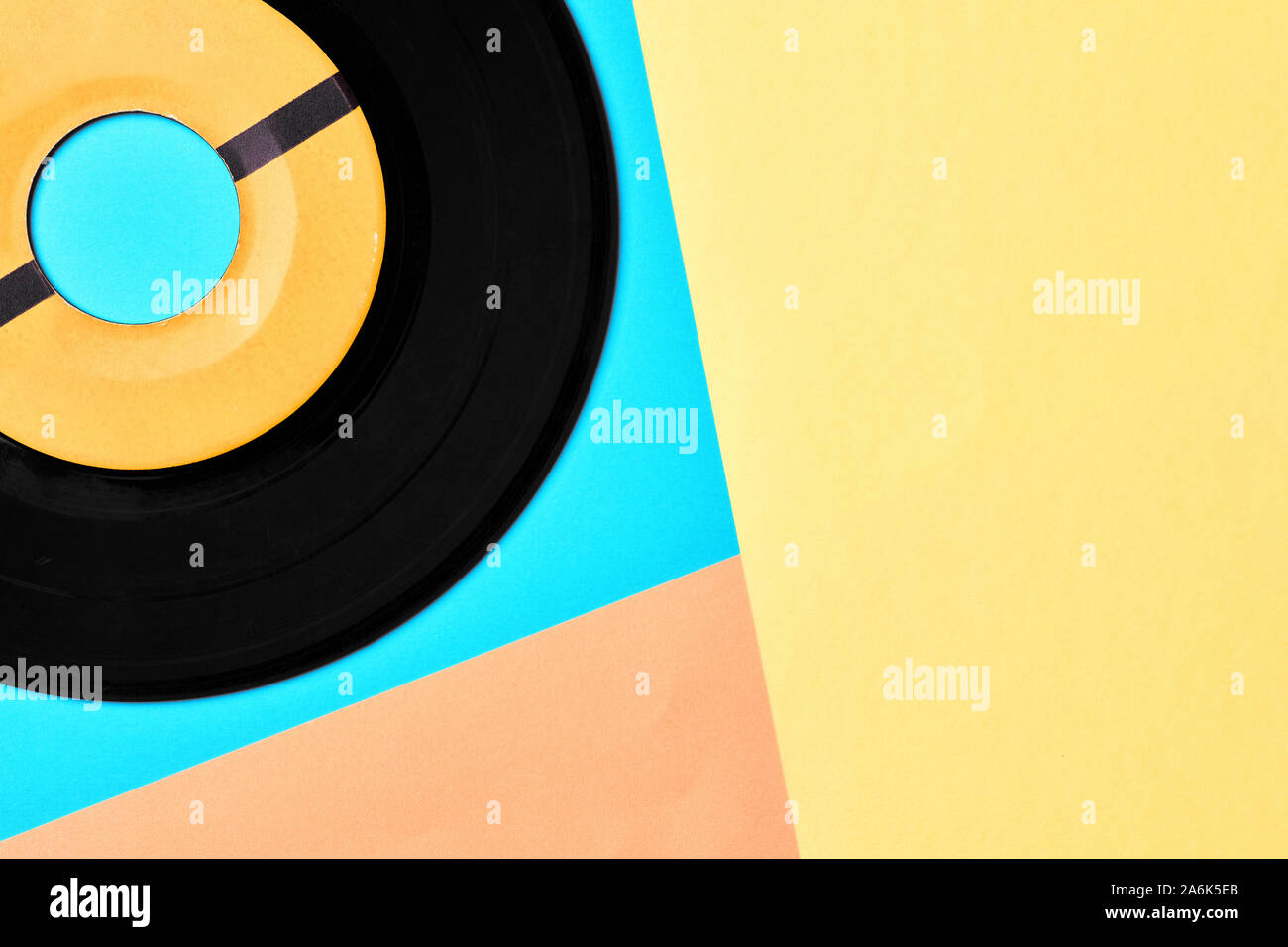 Vinyl record on pastel blue yellow and pink background. Overhead view ...