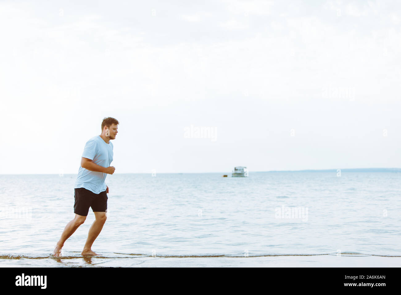 Man barefoot running beach handsome hi-res stock photography and images ...