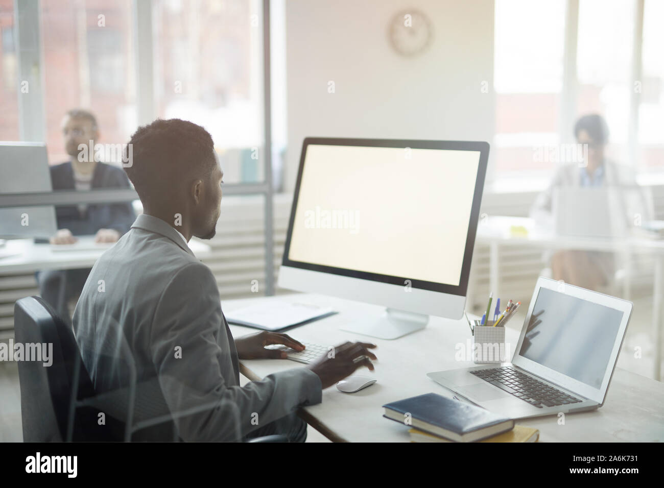 Back view portrait of African-American office worker using computer ...