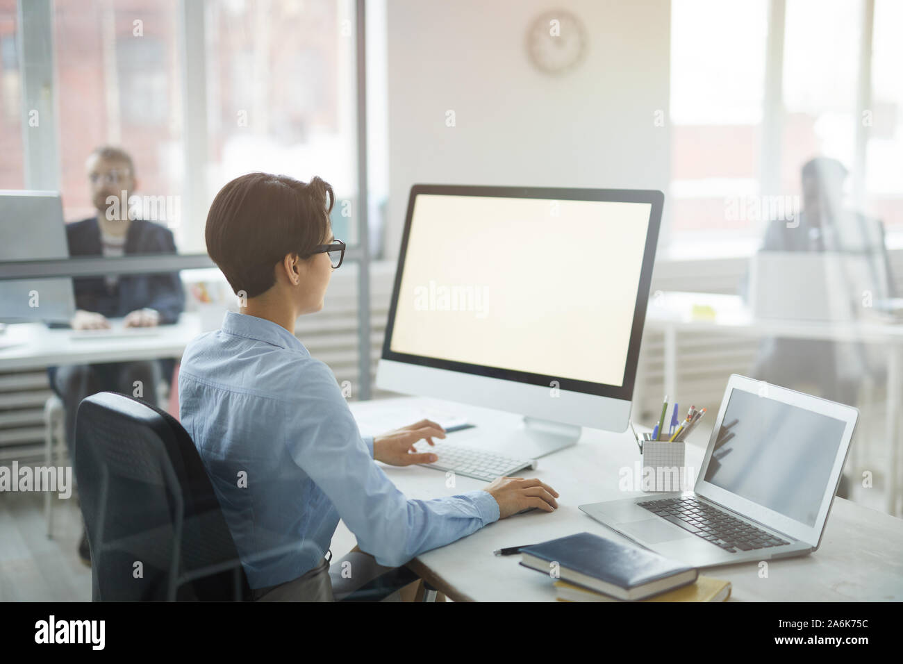 Back view portrait of young office worker using computer with black ...