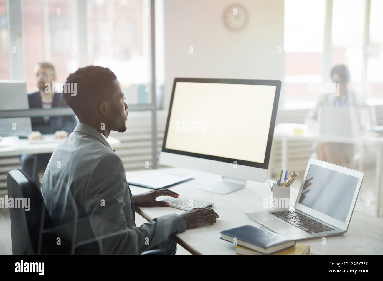 Side view portrait of African-American office worker using computer ...