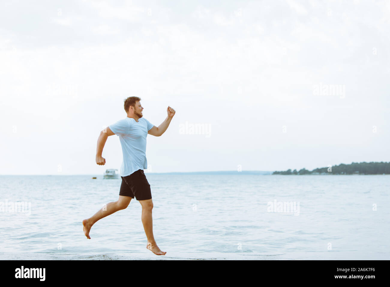 man running by sea beach barefoot Stock Photo - Alamy