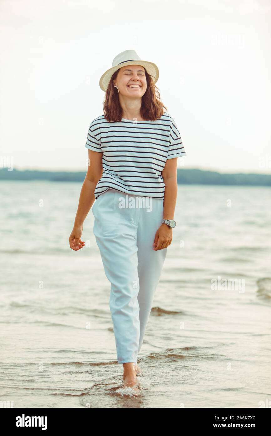 woman in white clothes walking by sea beach Stock Photo - Alamy