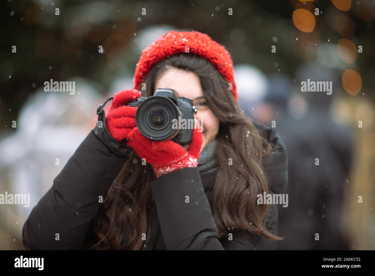 woman photographer with professional camera shooting outdoors at winter ...