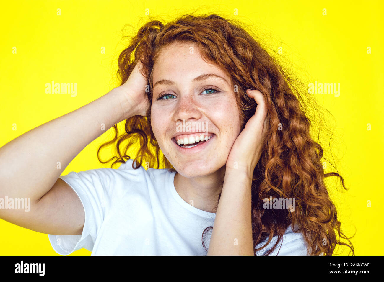 Portrait Of Beautiful Cheerful Redhead Girl With Curly Hair Smiling