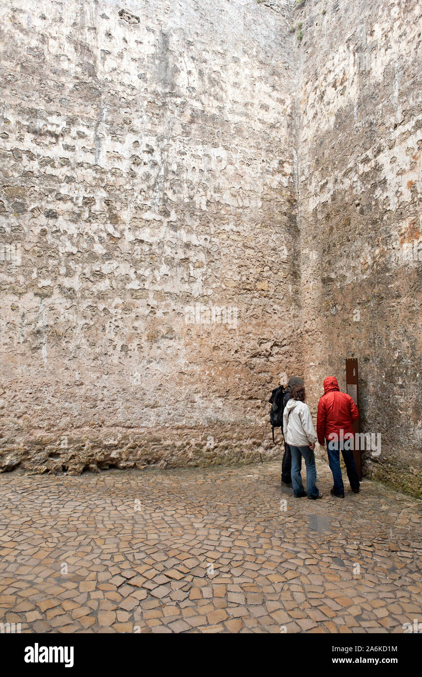 Visitors at Obidos castle inside the medieval walls reading information ...
